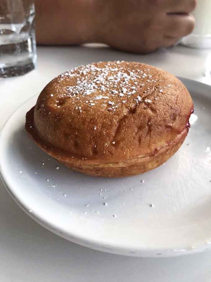 That golden, pillowy donut dusted with powdered sugar is basically a cloud you're allowed to eat for breakfast.