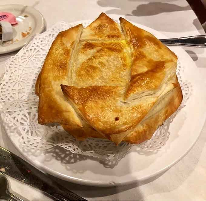 That golden puff pastry dome is hiding something wonderful, like a delicious secret waiting to be discovered.