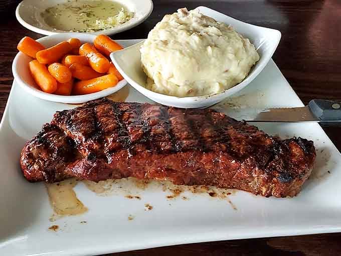 The New York strip arrives with sides that actually deserve to share the plate with such magnificent meat.