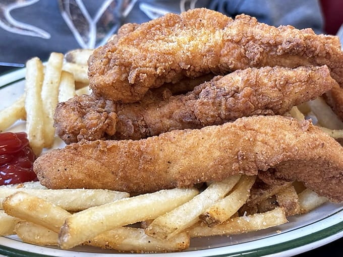 Chicken tenders so perfectly golden they could moonlight as edible sunshine on your plate with crispy fries alongside.