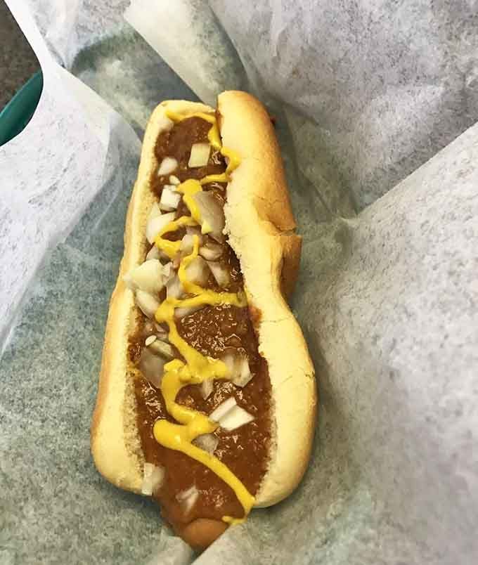 Chili, cheese, mustard, and onions create a symphony that requires multiple napkins and zero regrets.