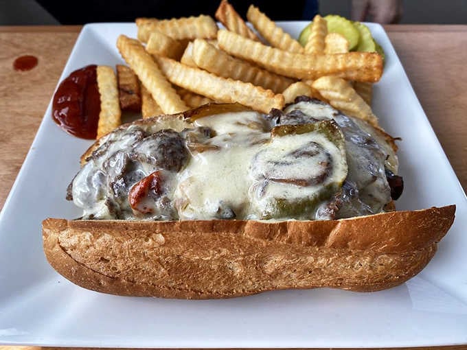 The Steak Bomb overflows with peppers, mushrooms, onions, and melted cheese like a delicious avalanche on bread.