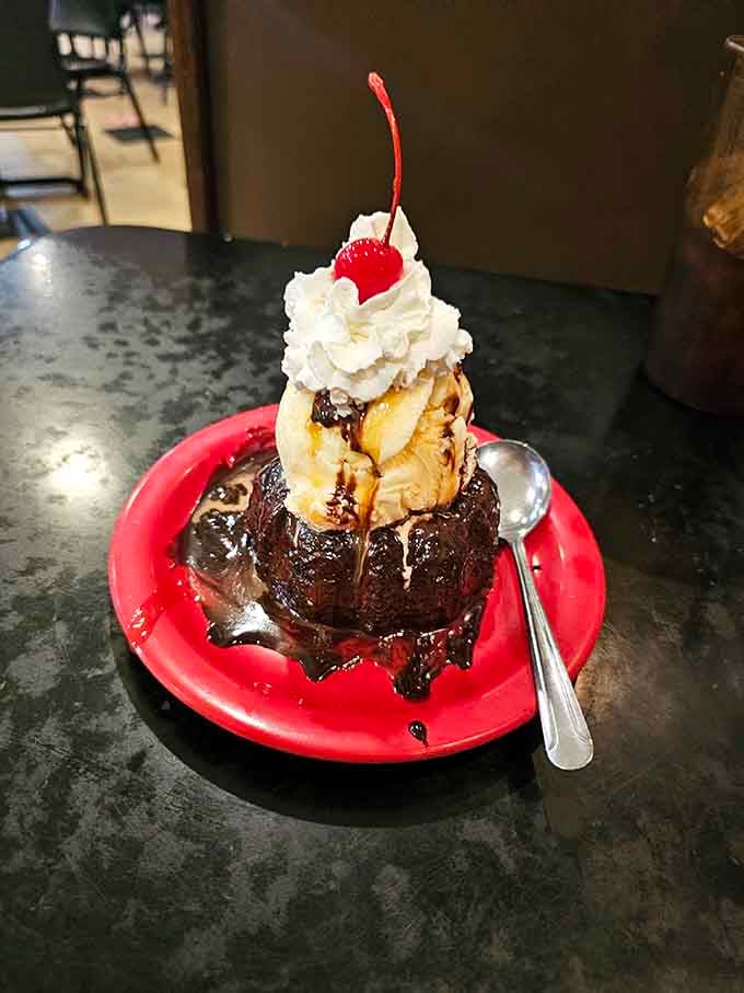 The chocolate molten cake topped with ice cream, whipped cream, and a cherry is pure indulgence on a plate.