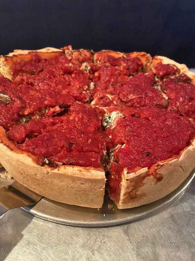 Layers of cheese and toppings creating the kind of cross-section that belongs in a food museum.