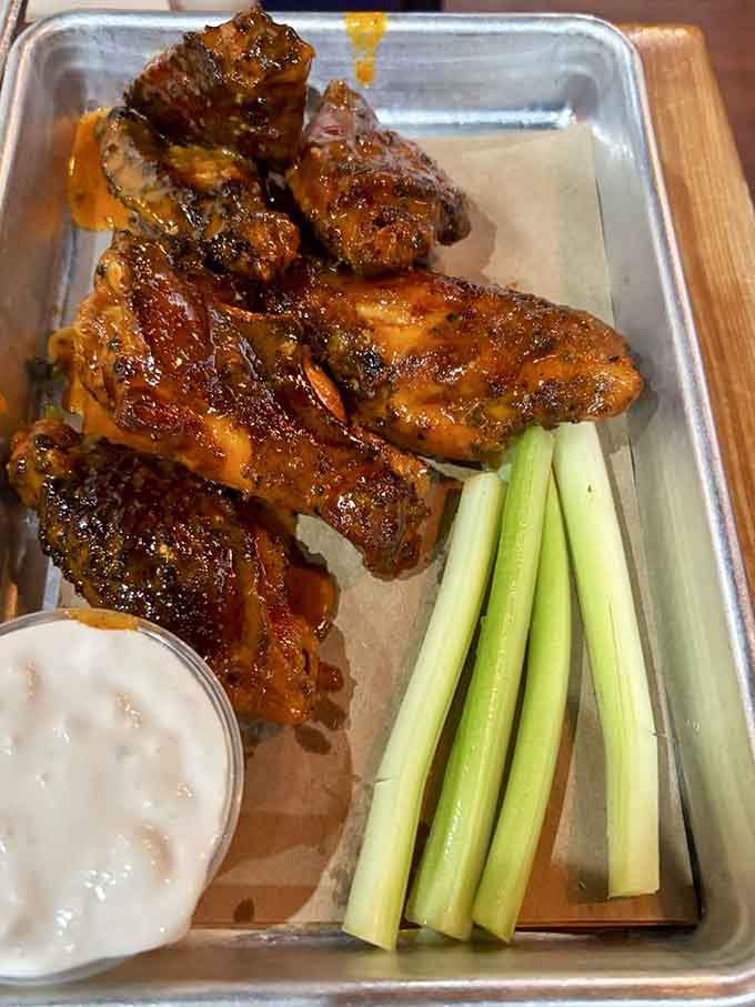 Wings glazed to glistening perfection, served with celery because someone thought you needed vegetables at a barbecue joint.