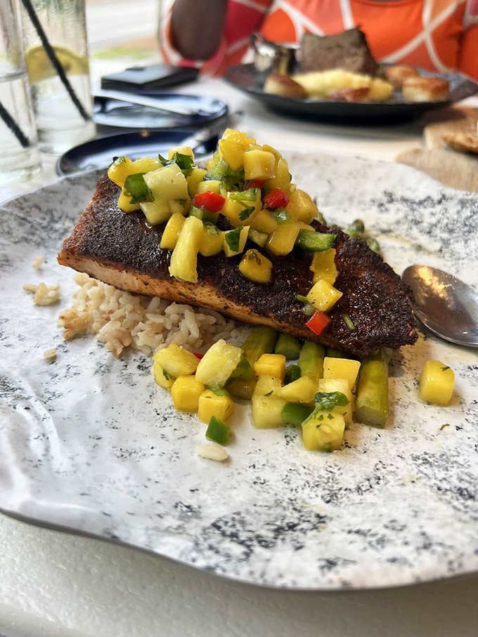 Blackened salmon sits pretty on Carolina gold rice, topped with pineapple mango salsa that screams tropical vacation on a plate.