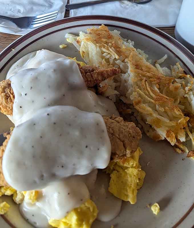 Country fried steak smothered in gravy alongside crispy hash browns is pure comfort on a plate.