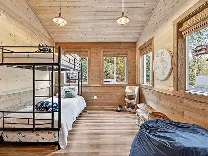 Natural wood walls and generous windows create a cozy sleeping space where kids dream of paleontology careers all night.
