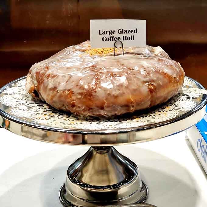 This glazed coffee roll is so large it needs its own pedestal, which honestly feels appropriate for royalty.