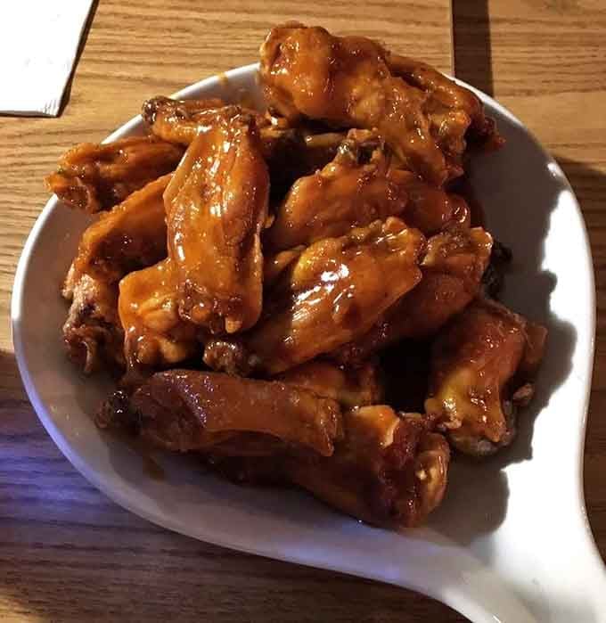 These wings have that glossy, sticky coating that requires extra napkins and zero regrets about your life choices.