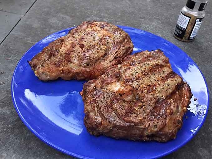 Ribeye steaks seasoned and ready to meet their destiny on the grill, because even German restaurants understand Texas priorities.