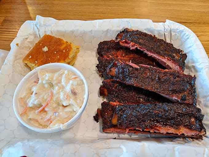 Ribs, cornbread, and coleslaw form the holy trinity of barbecue perfection on one glorious plate of happiness.