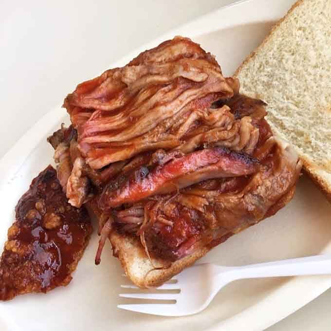 That's not just a sandwich, that's architectural engineering with smoked meat and white bread as building materials.