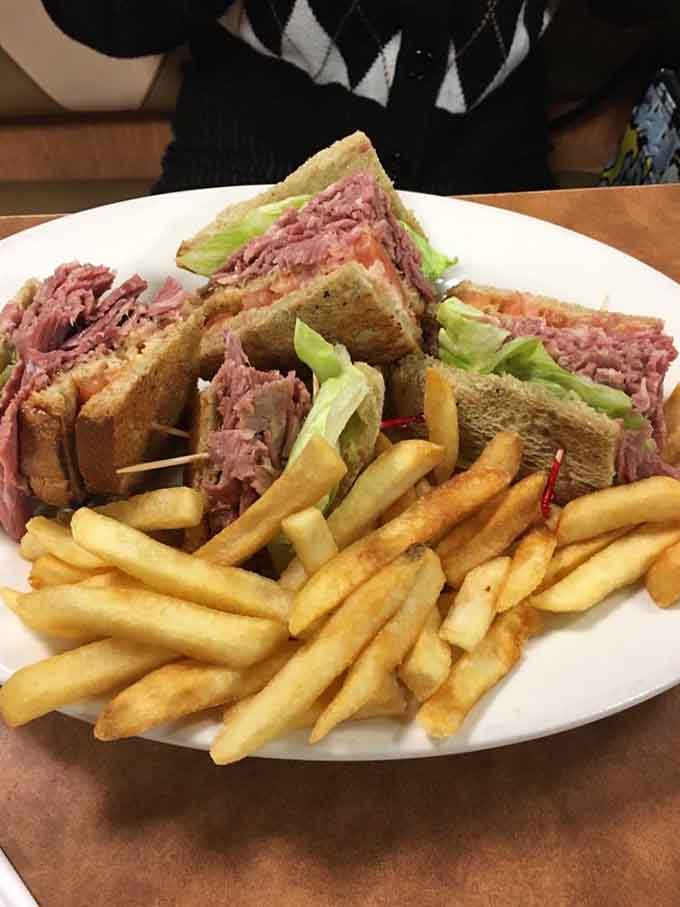 A corned beef sandwich stacked so high it requires architectural planning before your first bite.
