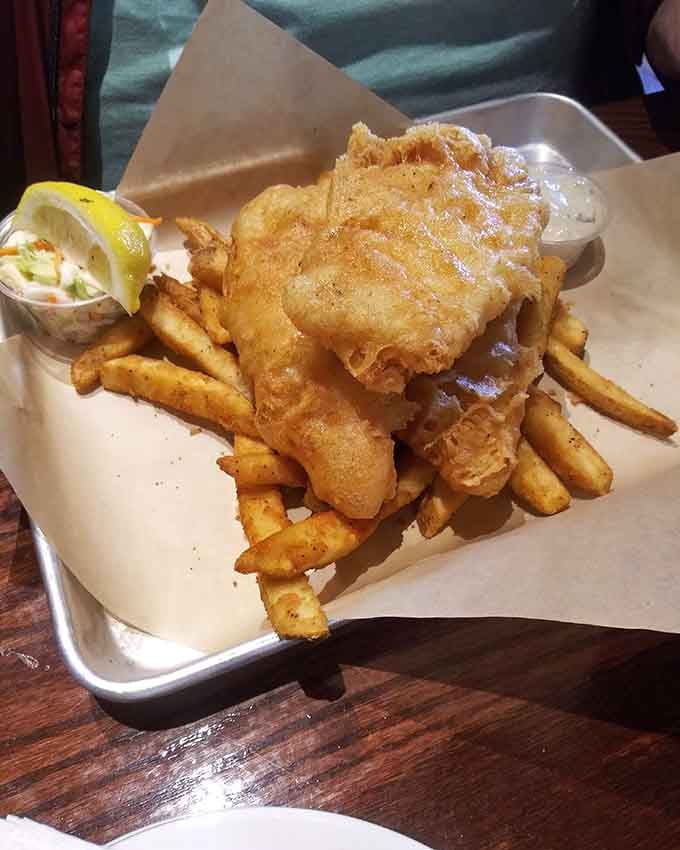 Golden battered fish perched atop crispy fries proves that some classics never need improving, just proper execution.