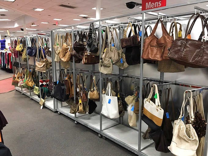 Purses hanging like a leather and canvas art installation, each one with its own mysterious past and future.