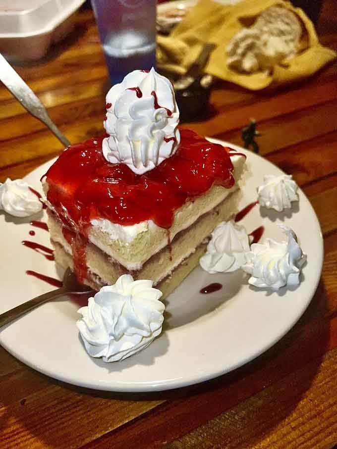 Strawberry shortcake towering with whipped cream that defies gravity and common sense, bless it.