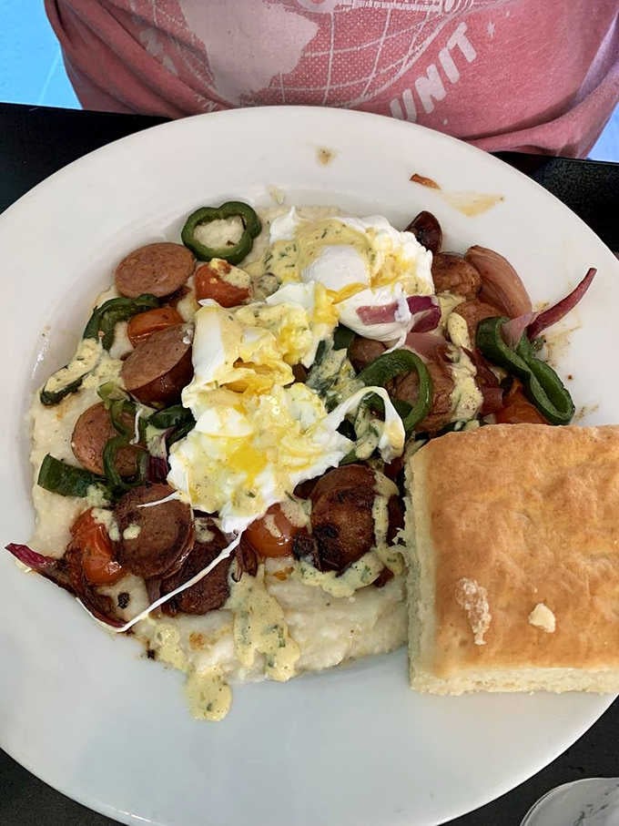 Scrambled eggs, grits, bacon, and a biscuit create the kind of plate that makes mornings worthwhile again.