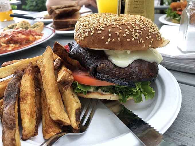 A sesame seed bun trying its absolute best to contain what appears to be burger-based chaos below.