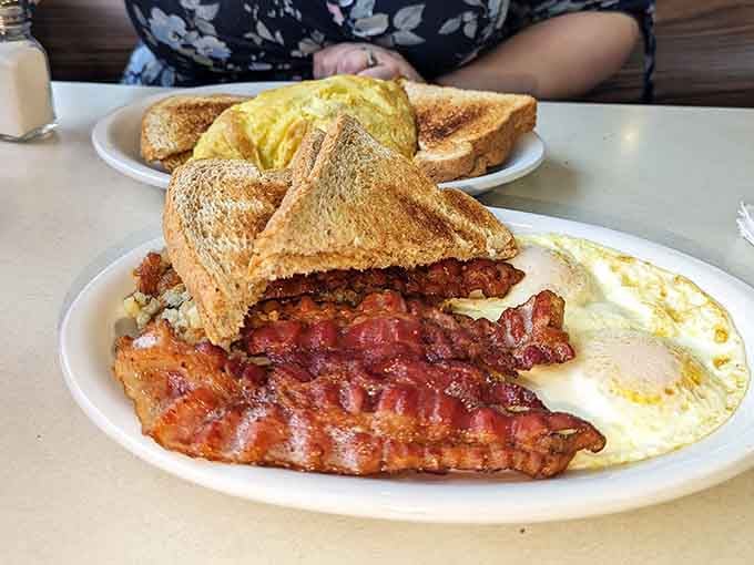 Bacon cooked just right, eggs waiting patiently, toast standing guard, this is breakfast doing its job correctly.