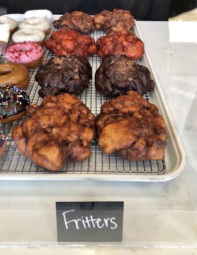 Fresh fritters cooling on the rack, looking like edible clouds that somehow got even more delicious than nature intended.
