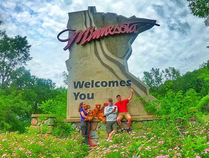 Nothing says "family road trip success" quite like posing with a sign that makes absolutely no geographical sense whatsoever.