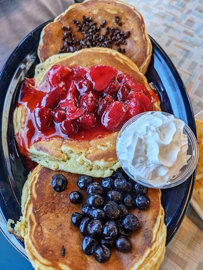 Pancakes topped with strawberries, chocolate chips, and blueberries prove that sometimes more really is more, and we're here for it.