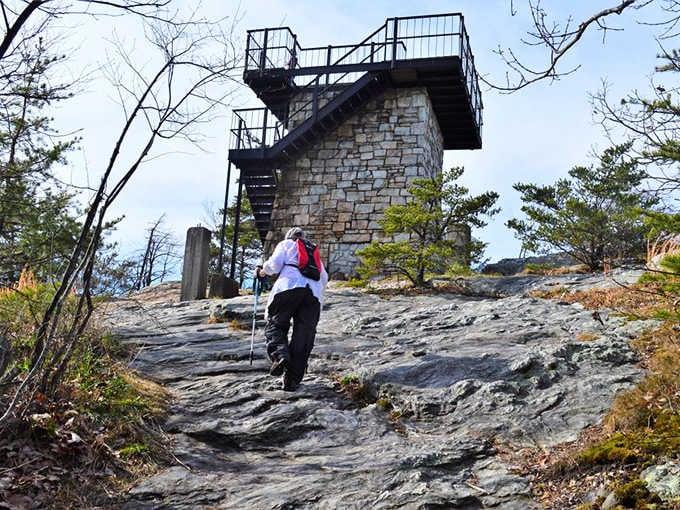 One hiker approaches the tower, backpack ready, about to discover why this spot earns all those five-star reviews.
