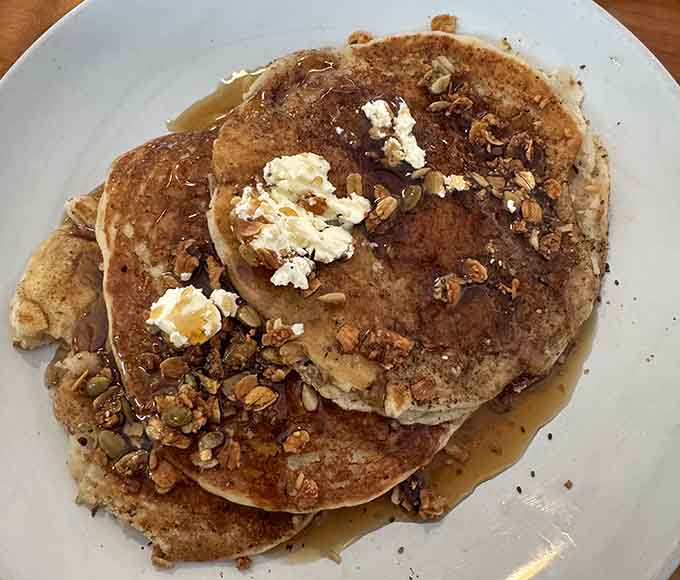 Fluffy pancakes topped with granola prove that breakfast can be both comforting and surprisingly sophisticated at once.