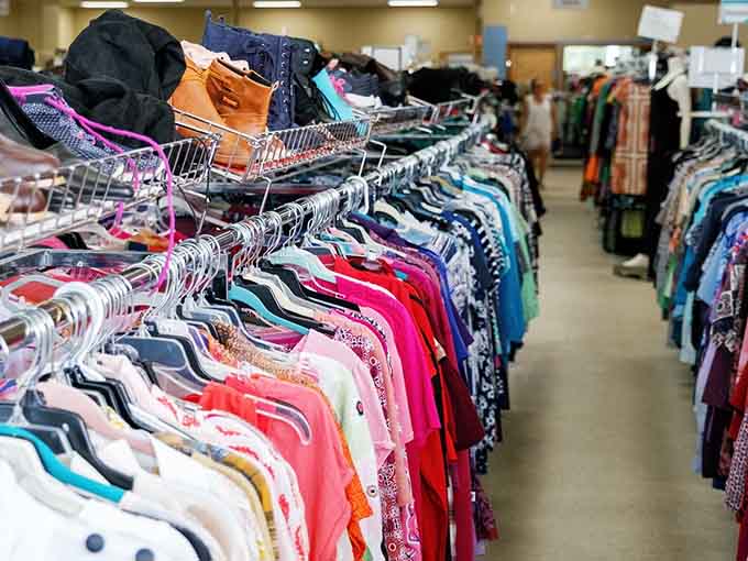 Clothing racks create colorful corridors of fashion potential, from casual wear to statement pieces waiting for rediscovery.