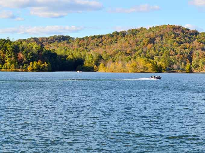 Boats glide across glass-smooth water while hills stand guard, creating postcards that write themselves every single day.