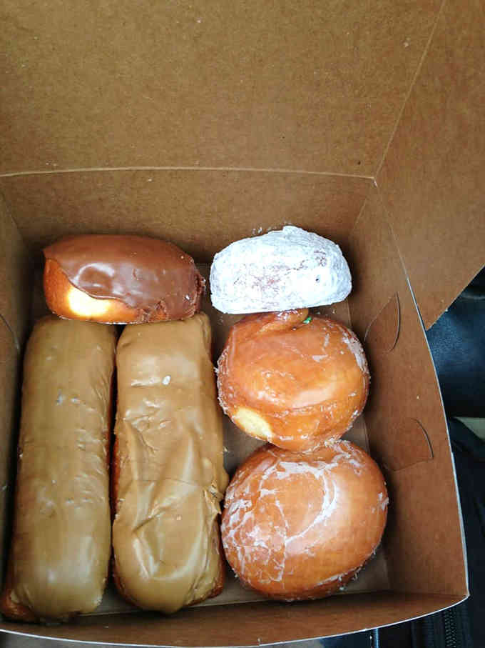 A perfectly curated selection showing chocolate, coconut, and those famous maple bars ready for their close-up.