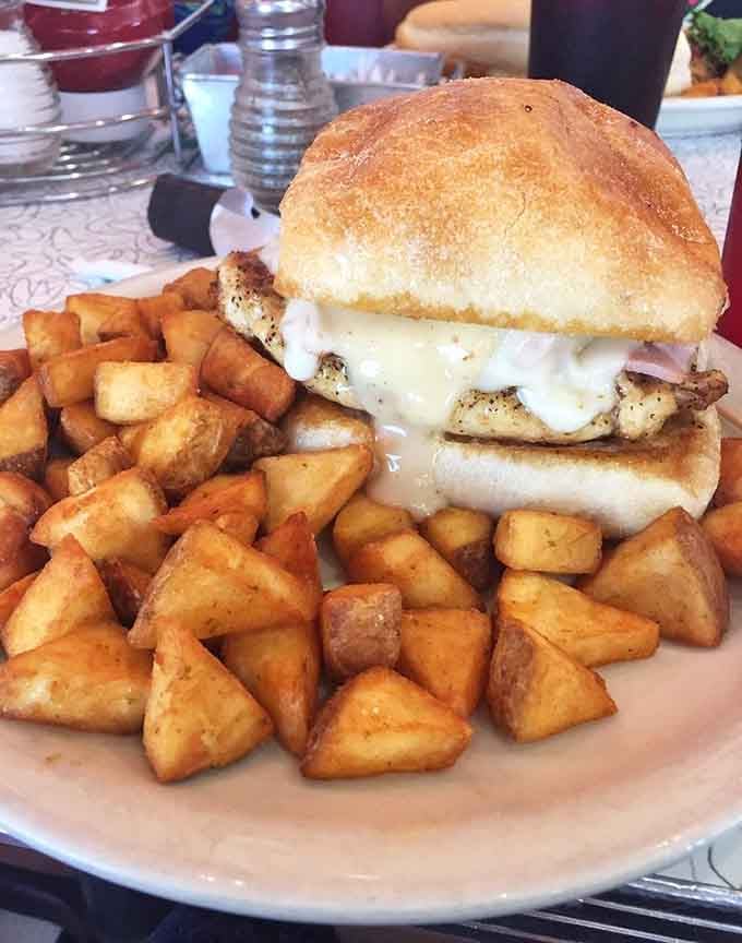 That chicken cordon bleu sandwich surrounded by crispy potatoes is basically a hug on a plate with sides.