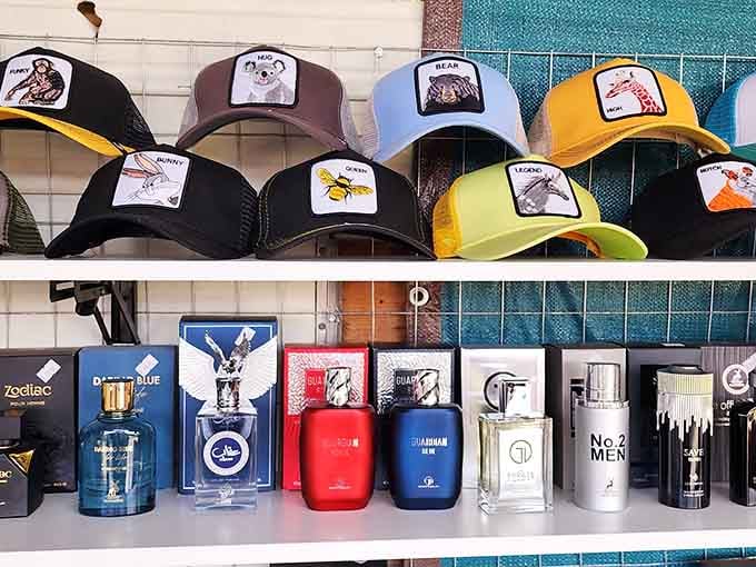 Trucker caps and cologne bottles share shelf space in the most unexpectedly perfect retail marriage.