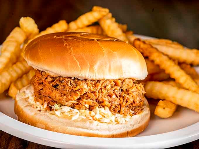 Pulled pork piled high on a soft bun with crispy fries, this is what lunch dreams are made of.