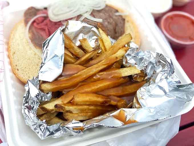 Gravy-covered fries in foil alongside a loaded sandwich, this is comfort food that actually comforts your soul completely.