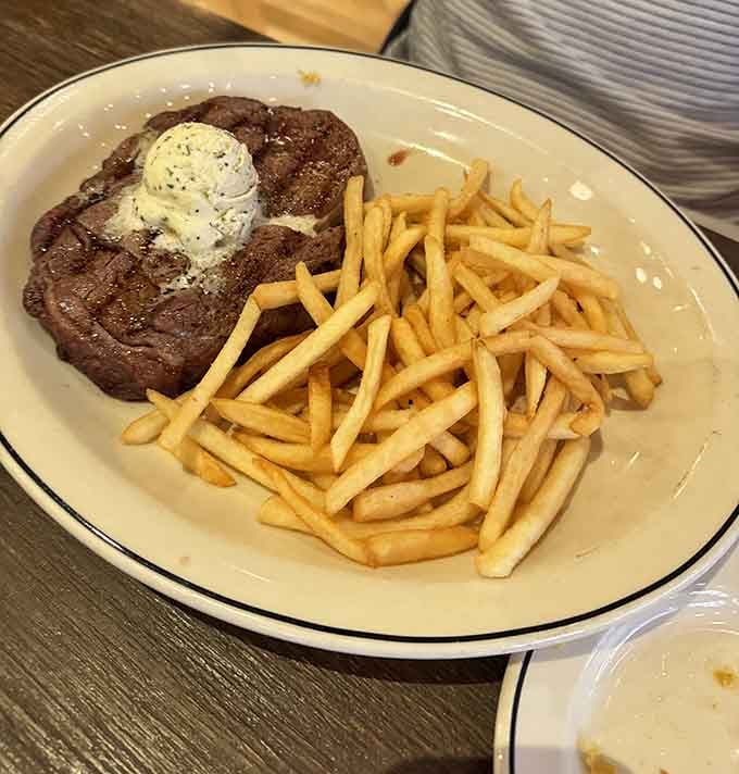 The ribeye steak sits proudly with garlic herb butter, ready to make your carnivorous dreams come true.