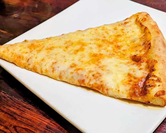 One glorious slice of cheese pizza, folded New York-style, ready to make your lunch break legendary.