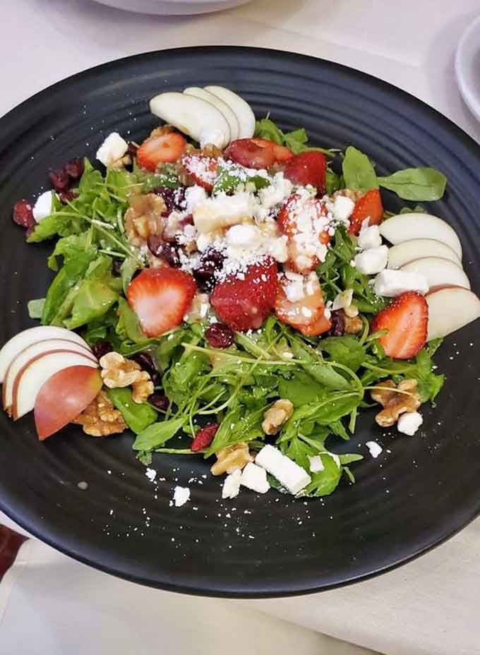 Fresh strawberries, apples, walnuts, and goat cheese transform a simple salad into something worth driving across town for.