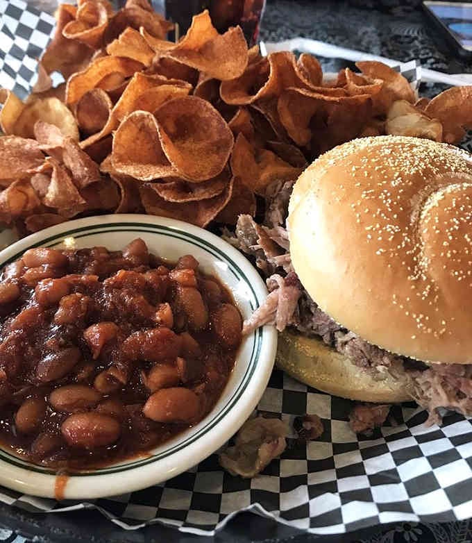 A pulled pork sandwich with beans and fresh chips is comfort food that would make your grandmother nod with approval.