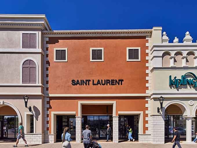Saint Laurent's bold signage against terracotta walls creates an unexpectedly chic contrast for outlet shopping.