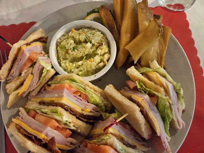 Sometimes you need both hands free from crab-picking duty, and this towering club sandwich delivers exactly that satisfaction.