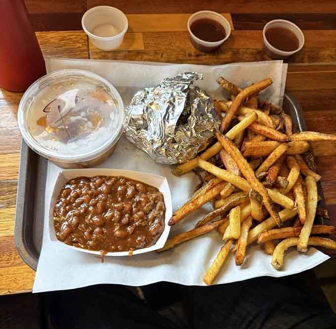 Hand-cut fries piled high alongside golden fried okra, proving that vegetables absolutely belong at a barbecue feast when properly prepared.