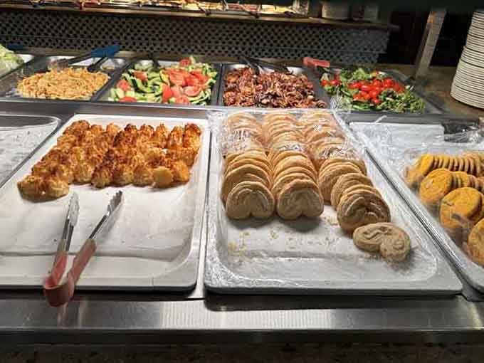 The dessert station stretches endlessly with cakes, pastries, and treats that make every previous course feel like mere preparation.