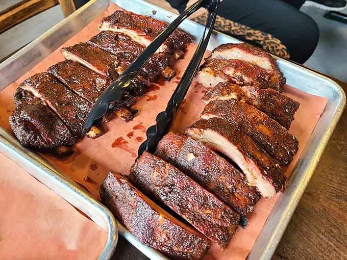 Baby backs and St. Louis ribs resting on butcher paper, their mahogany bark glistening like edible treasure from the smoker.