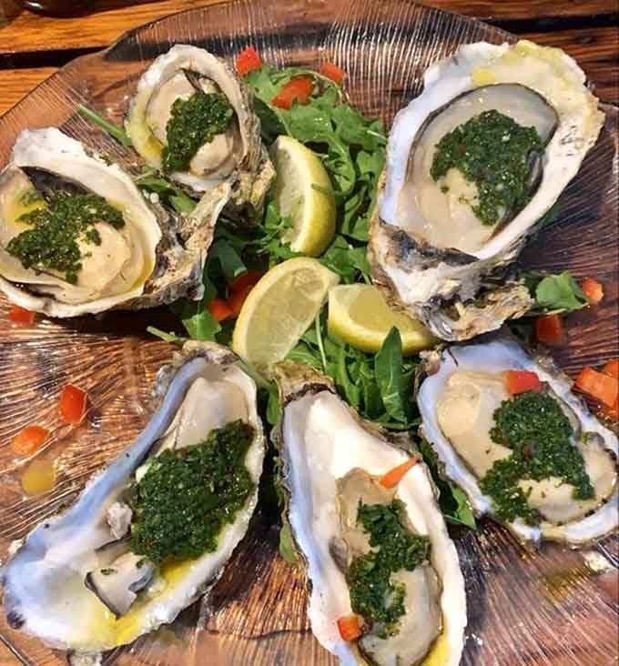 Oysters glistening with that vibrant green sauce, ready to transport you straight to seafood heaven.