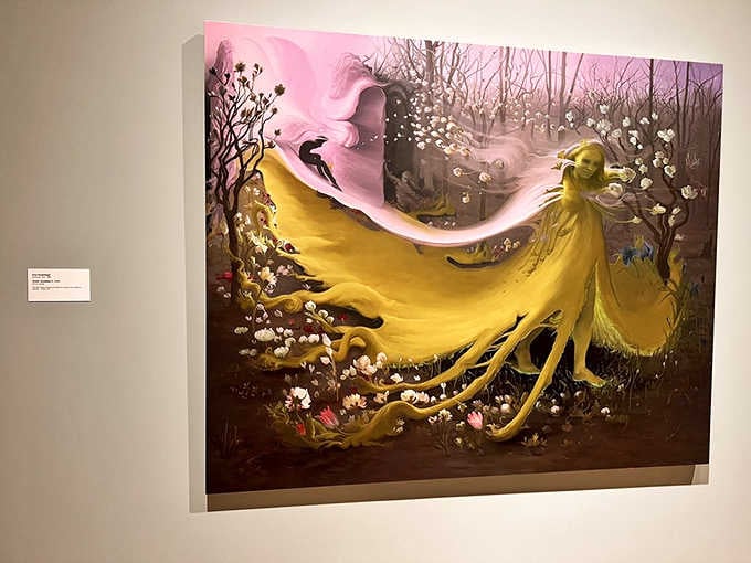 A yellow-cloaked figure drifts through dreamlike landscapes in this painting that feels like visual poetry come alive.