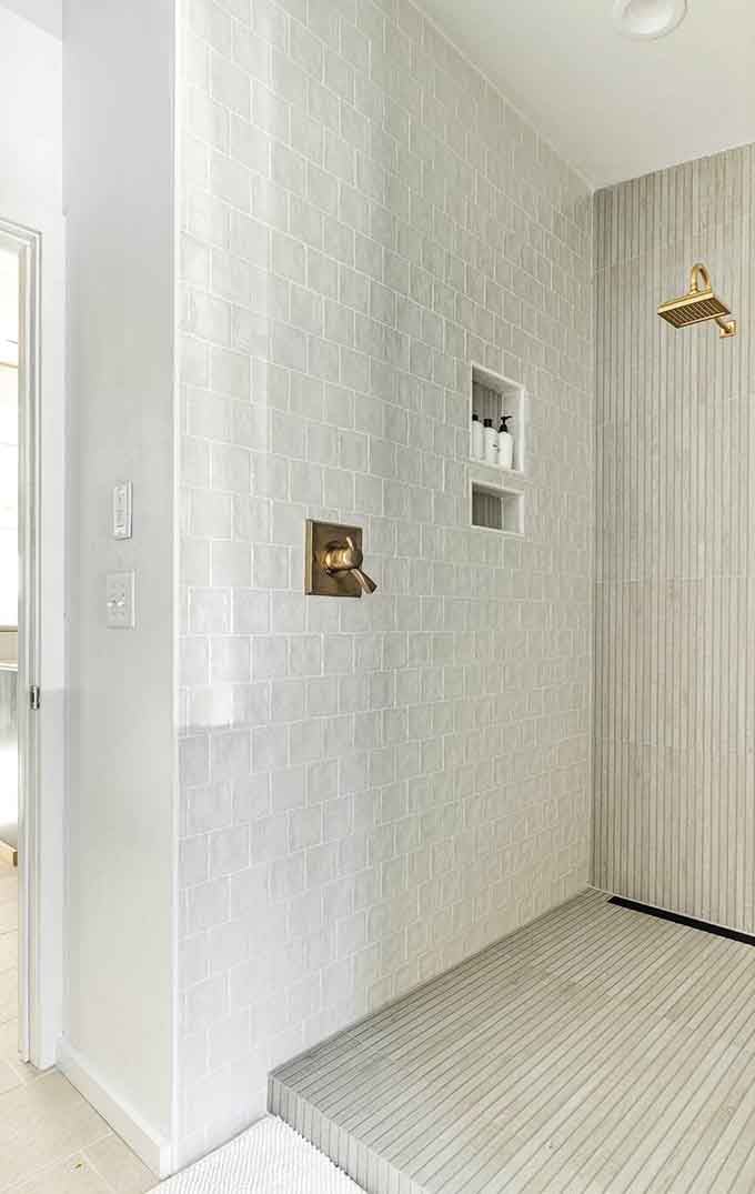 White subway tiles and brass fixtures create a shower experience that's somehow both spa-like and refreshingly unpretentious.