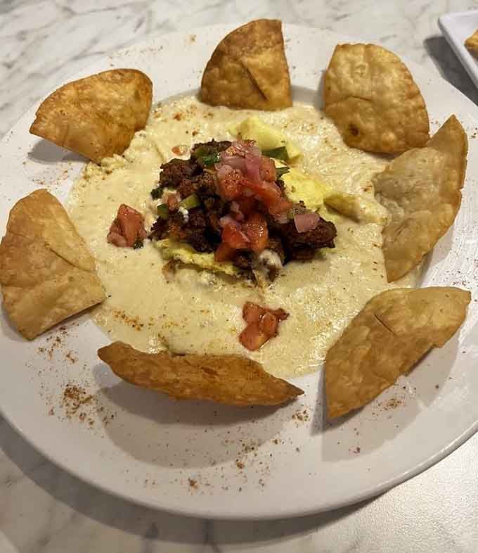 Breakfast nachos arranged like a superhero's shield, because sometimes tortilla chips need waffles to complete their mission.