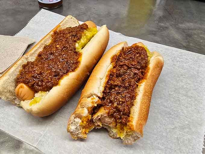 Two chili dogs blanketed in meaty goodness, proving that sometimes the best things come in the messiest packages.
